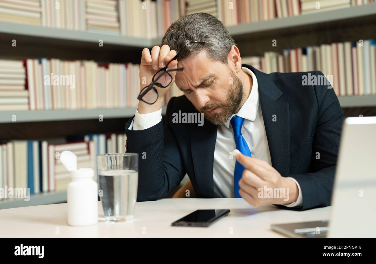 Business man suffering from headache after computer work, exhausted ...