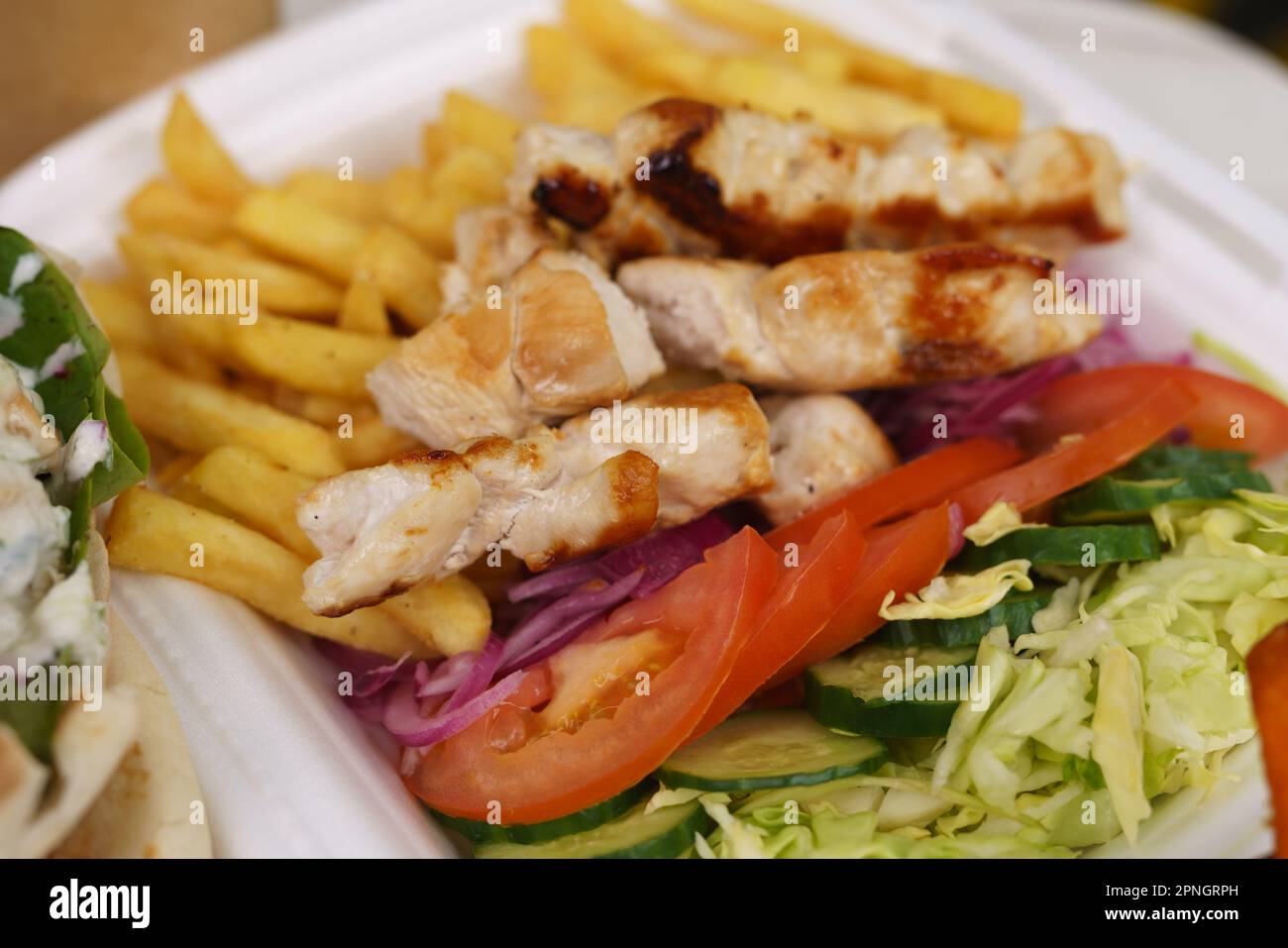 Lunch box with roasted pork meat, fresh vegetables and fries ...
