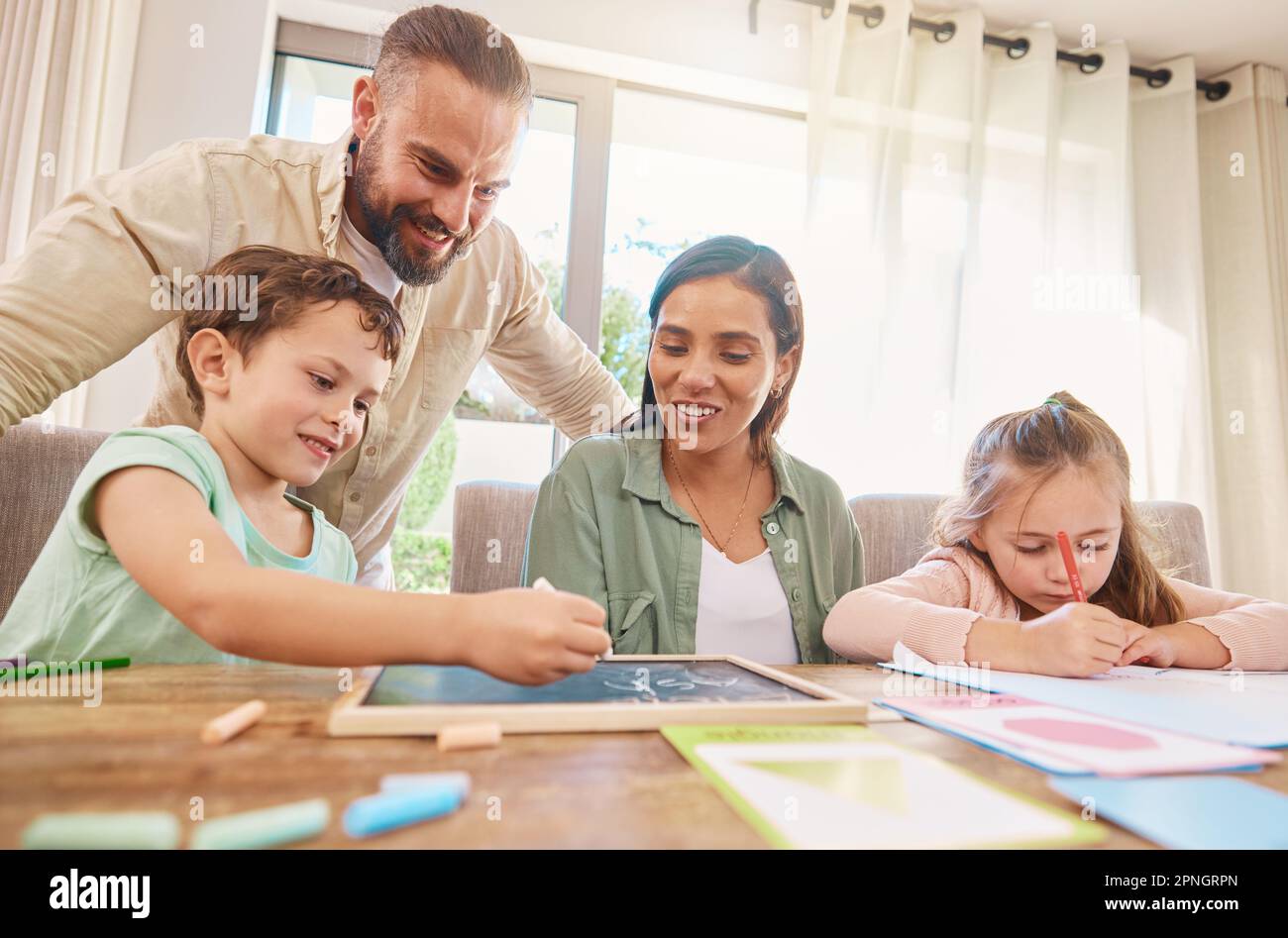 Family, education and homework with a boy writing on a chalkboard while ...