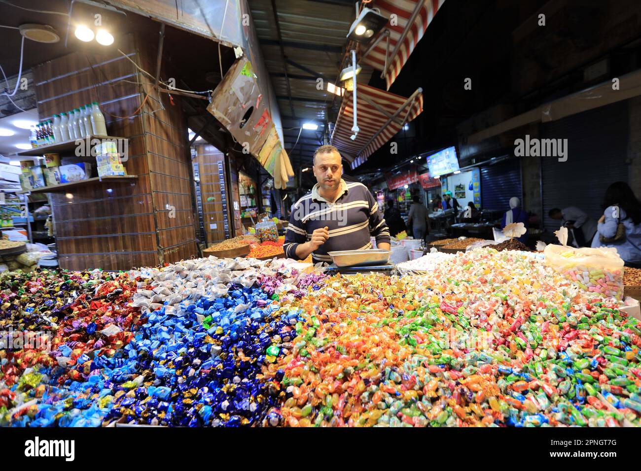 Amman, Jordan. 18th Apr, 2023. A vendor arranges candies in a market in downtown Amman, Jordan ...