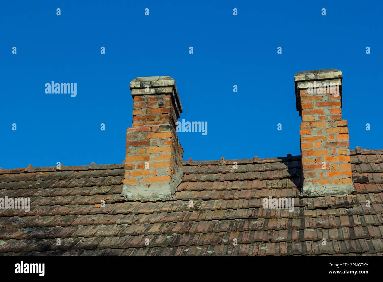 red brick chimney in the top of the village house. A roof made of tiles ...