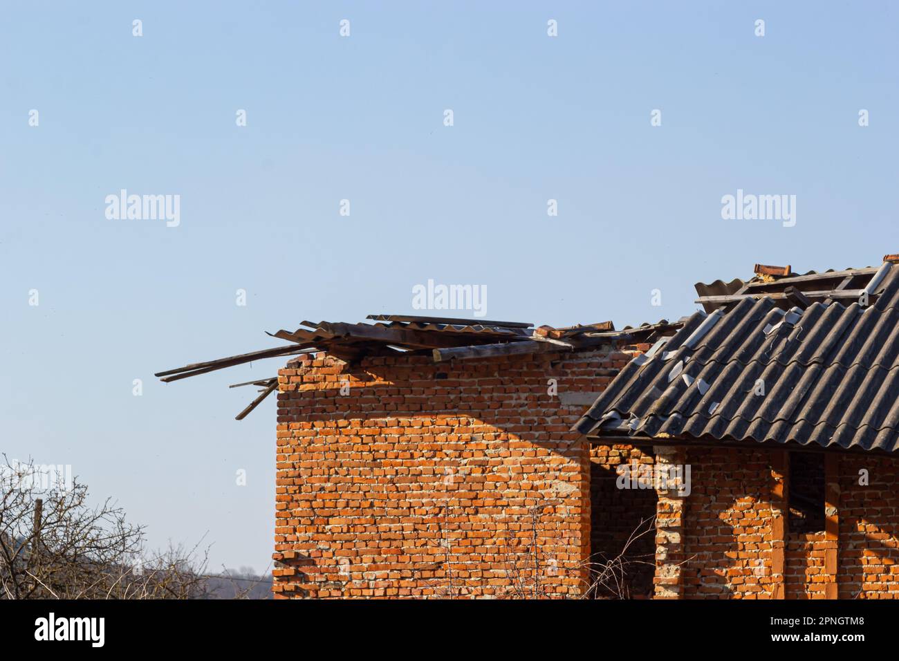 Destroyed roof of brick house. Destroyed house after a storm or as a ...