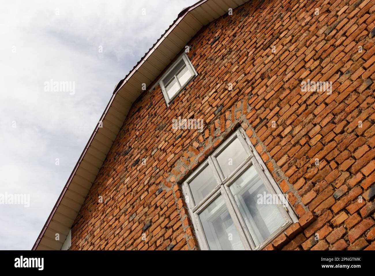 Red brick wall with windows. Bottom view on the background of the sky ...