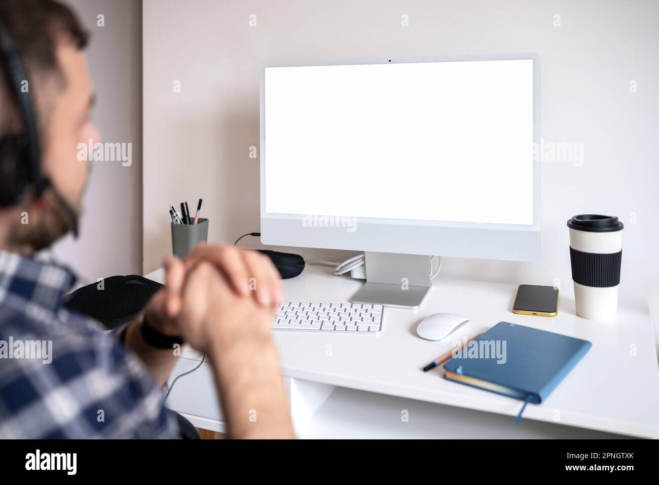 Blank screen computer monitor, man sitting at desk and looking at ...