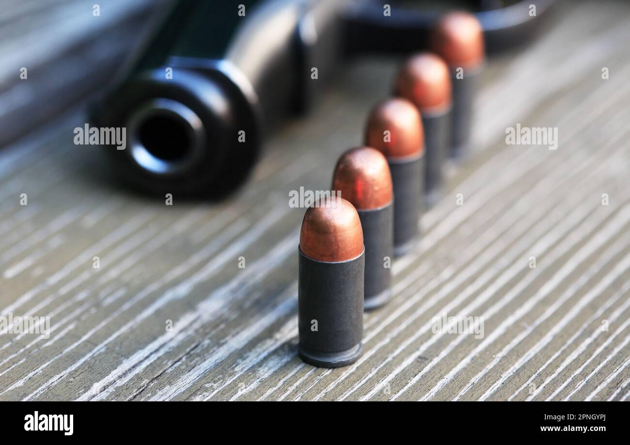 Handgun cartridges closeup on old wooden background near pistol Stock ...