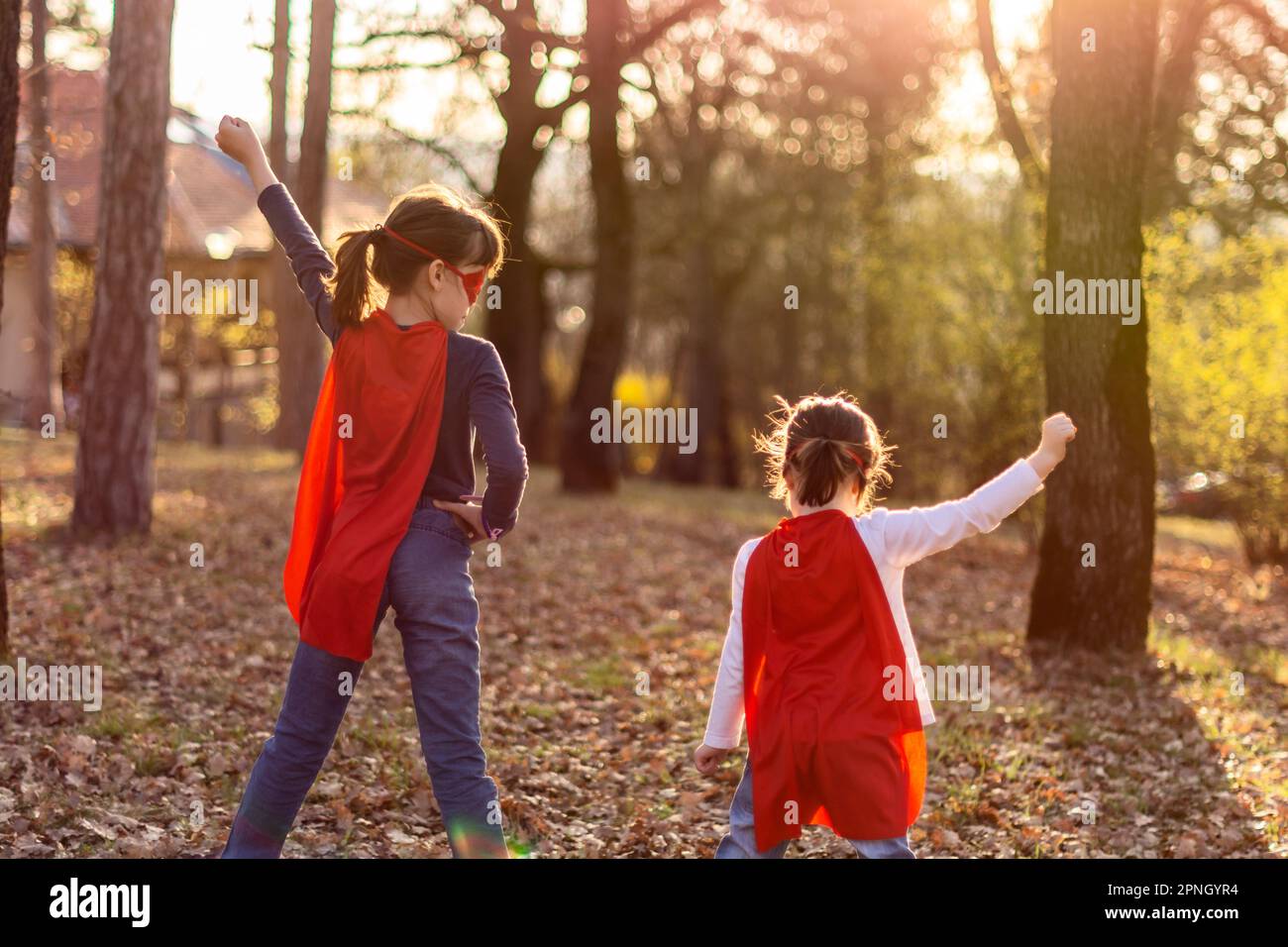 Rear view of superhero children standing in park - girl power Stock ...