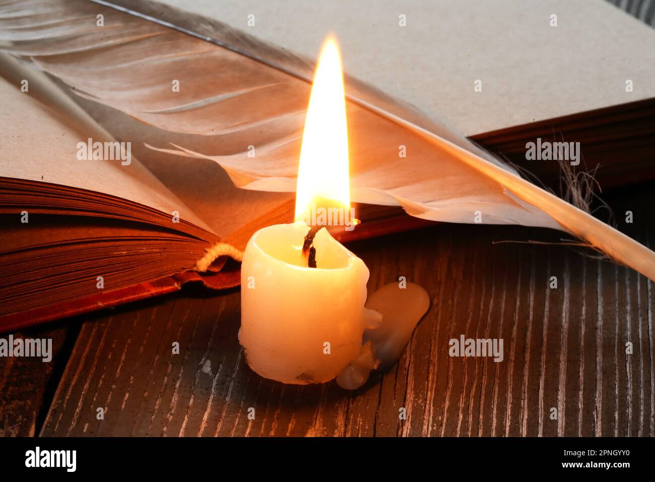 Art concept. One lighting candle near open notebook and quill pen Stock ...