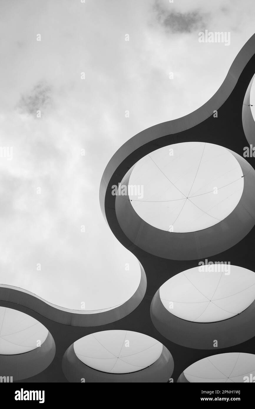 A grayscale of a circular structure on the background of the cloudy sky ...