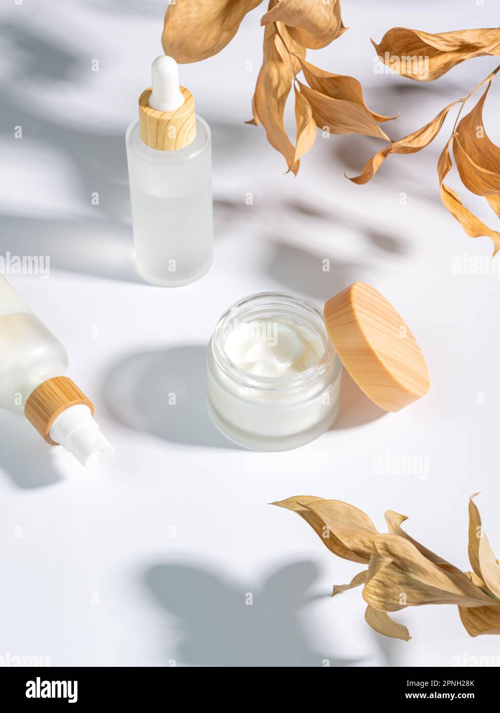 close up of collagen cream in glass jar, serum in white matte glass ...