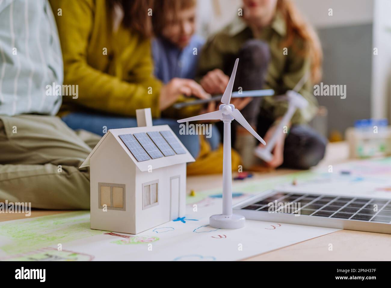 Close-up of house model with solar system and wind turbine during a ...