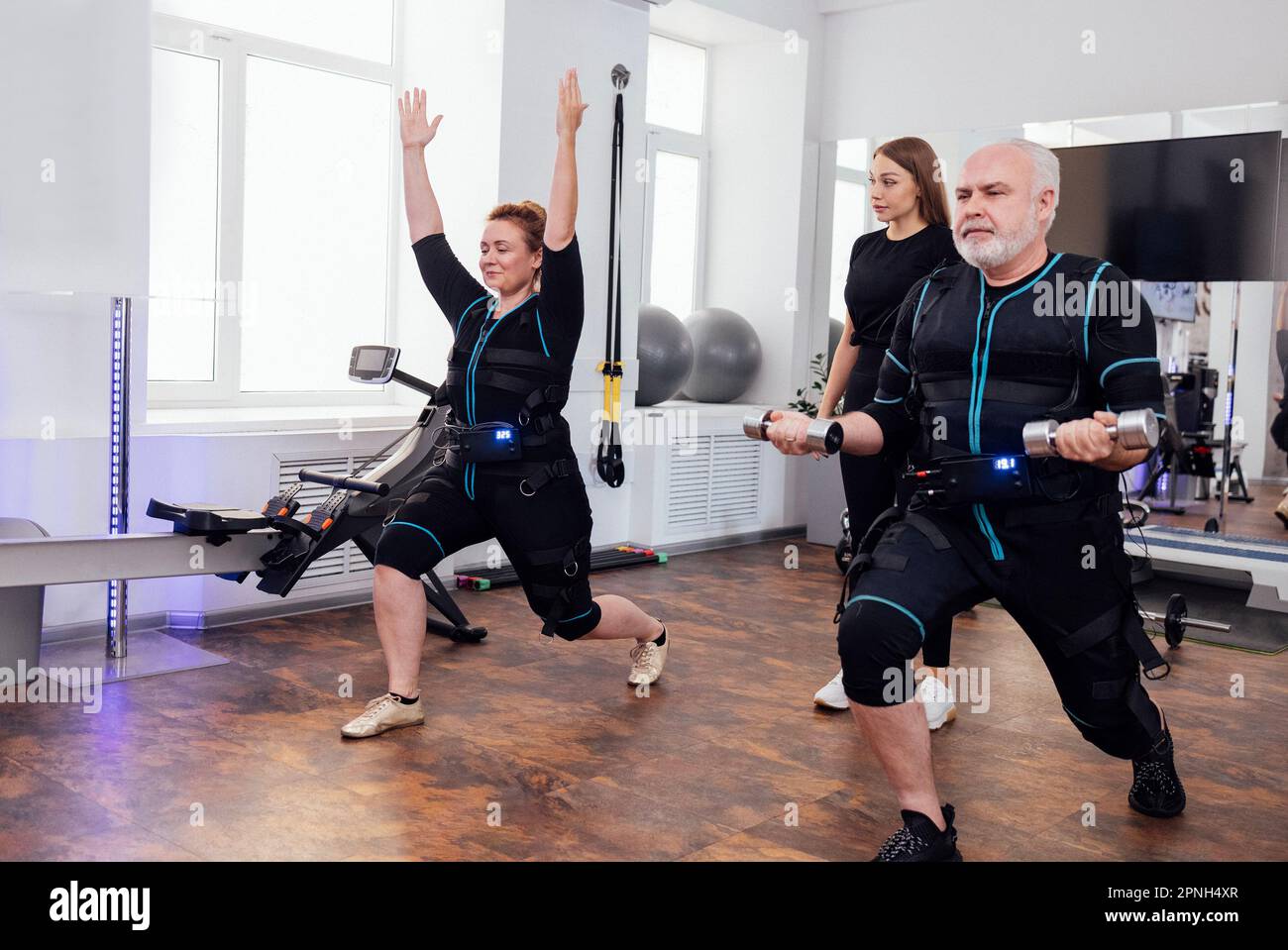 Eldery couple in ems suits doing electrical muscle stimulation workout ...