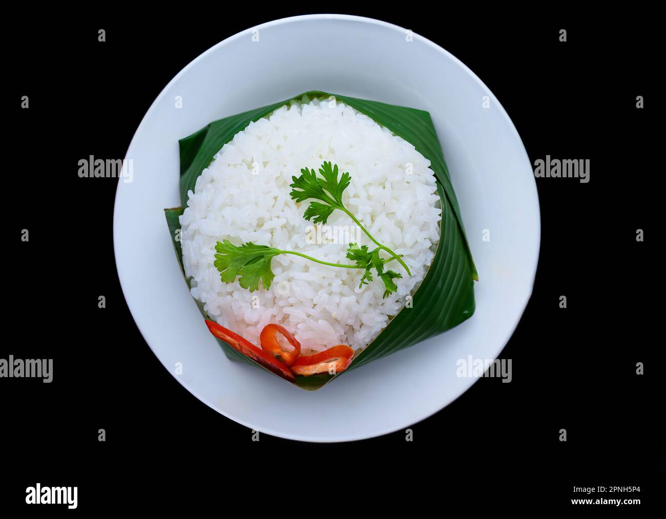 Vietnamese white rice in banana leaf isolated on black background for a ...