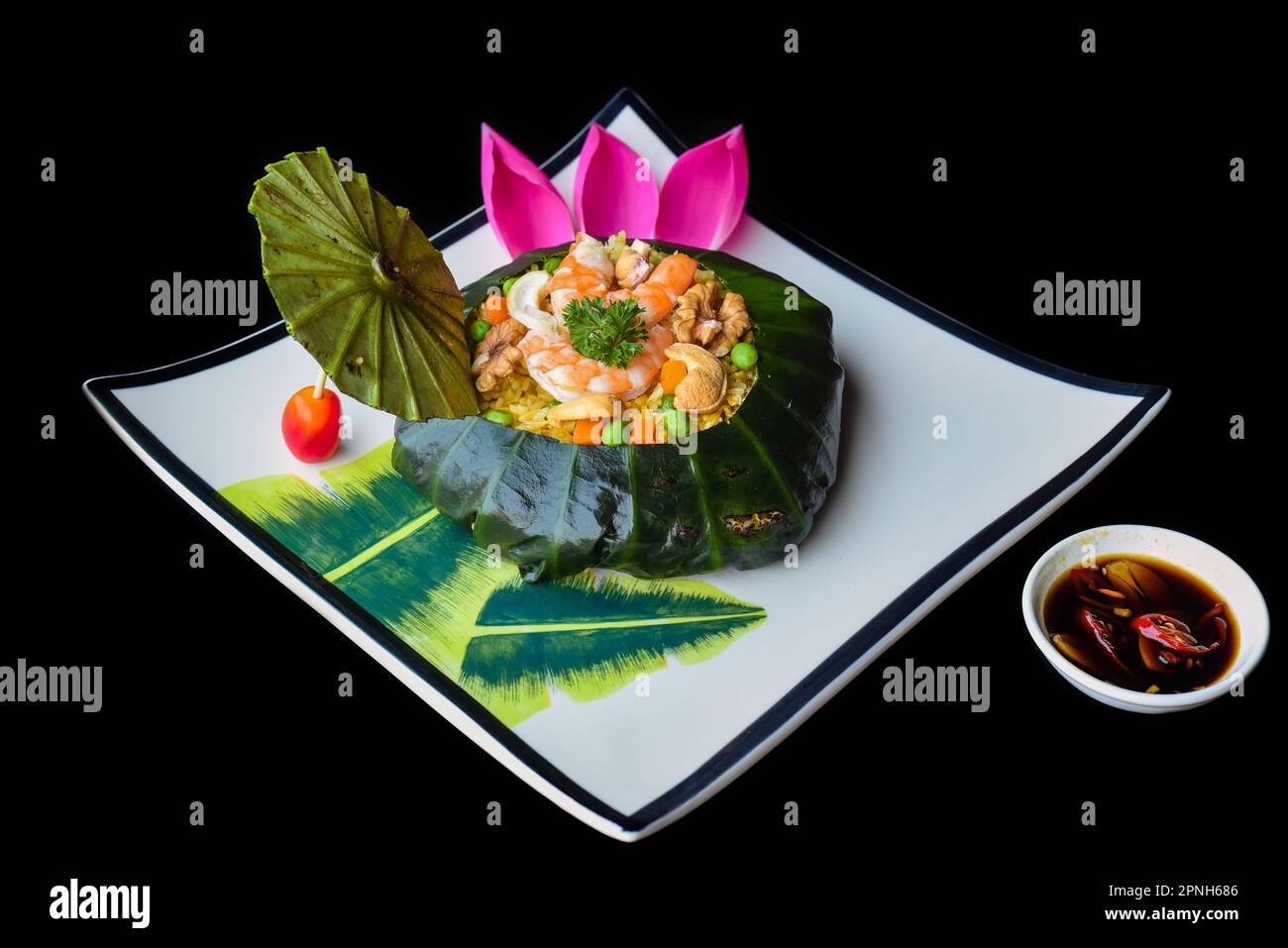 Vietnamese fried rice with vegetables, nuts and shrimps in lotus leaf ...