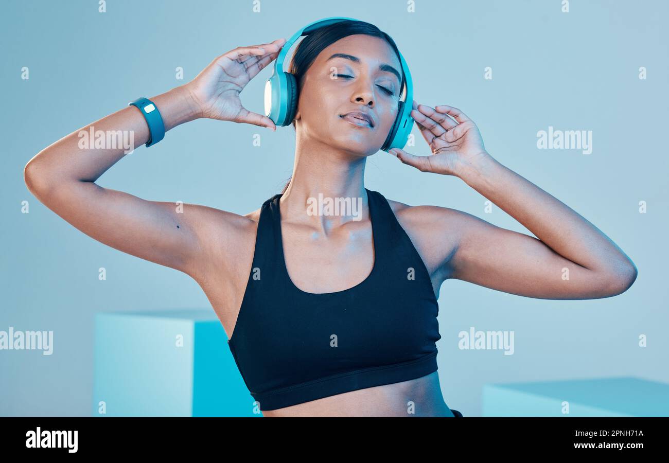 Headphones, fitness and woman isolated on blue background for workout ...