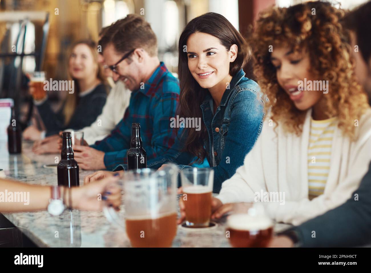 Where they come to unwind. people enjoying a drink at a bar Stock Photo ...