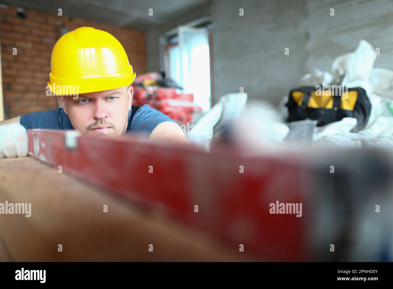Bricklayer checks evenness of brick wall, brick foundation using spirit ...