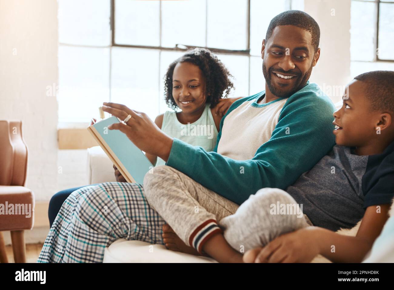 Hes the best story teller. a father and his children reading a book ...