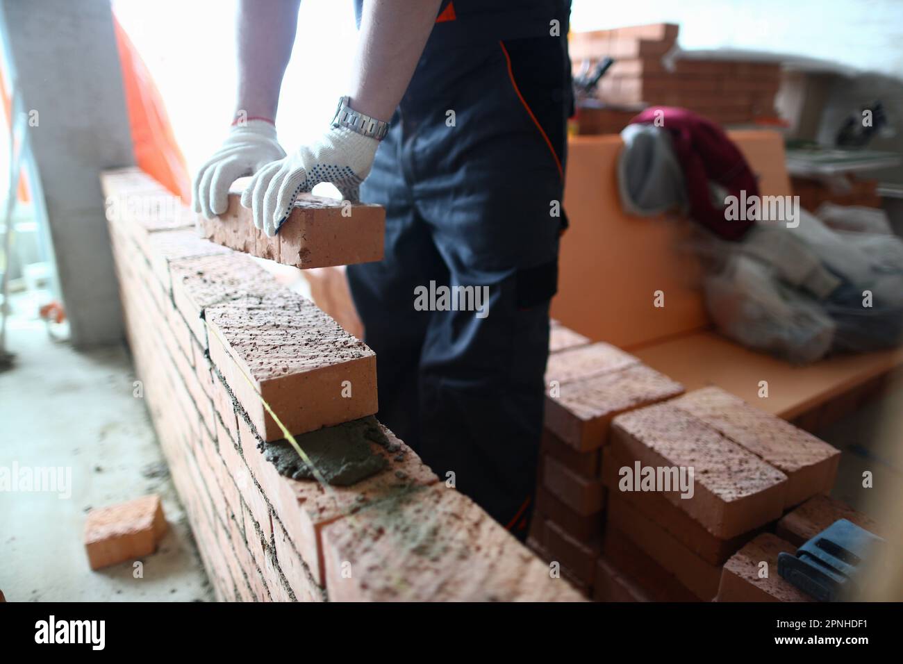 Closeup of industrial bricklayer laying bricks at construction site ...