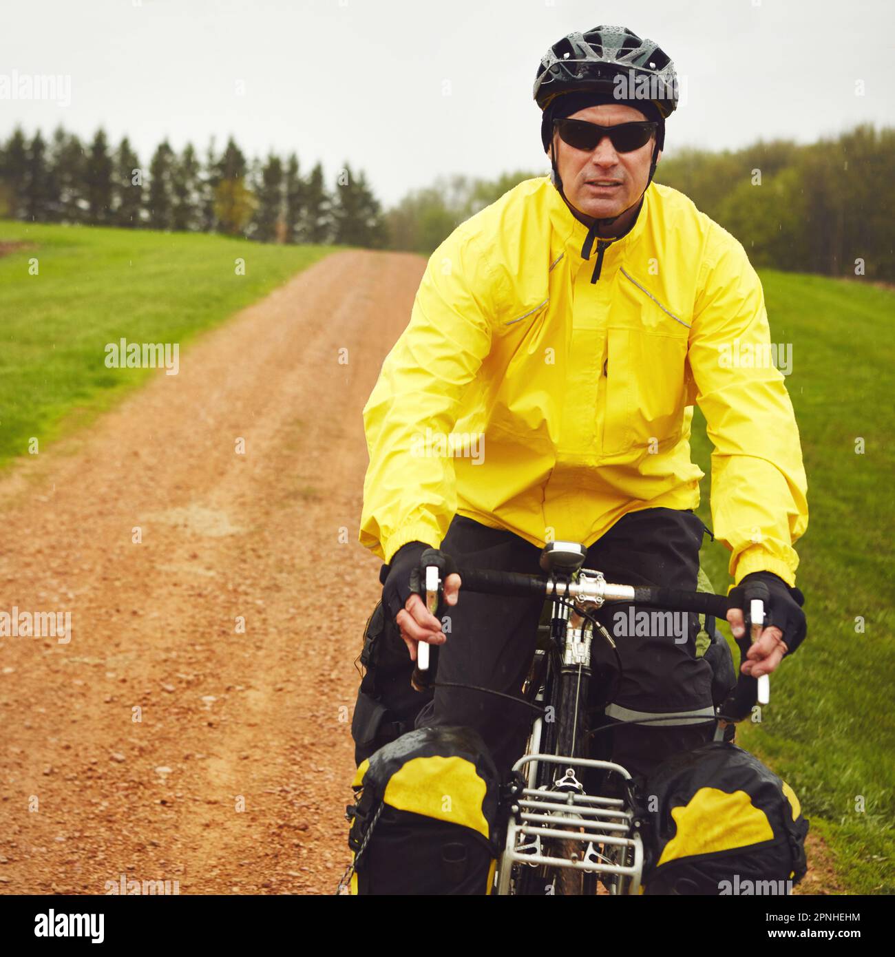 Have wheels, will ride. a male cyclist enjoying a bike ride on a wet ...