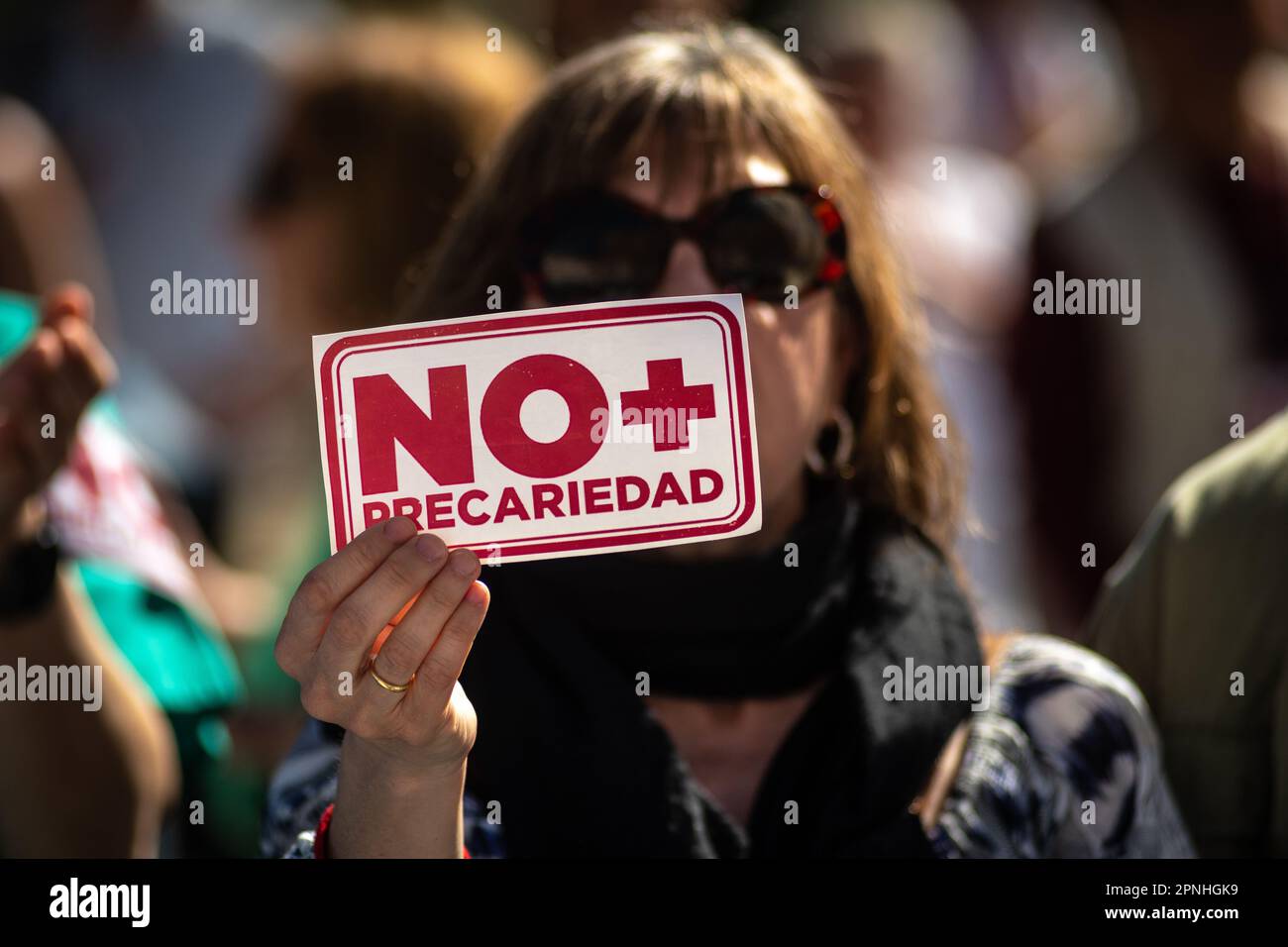 Madrid, Spain. 19th Apr, 2023. A woman holds a sticker with the words ...