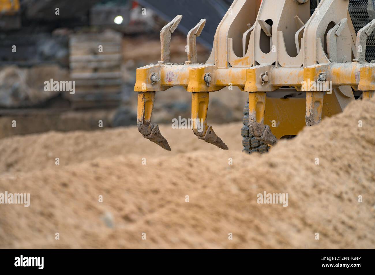 Rear scarifier tines of a grader working in sand Stock Photo - Alamy
