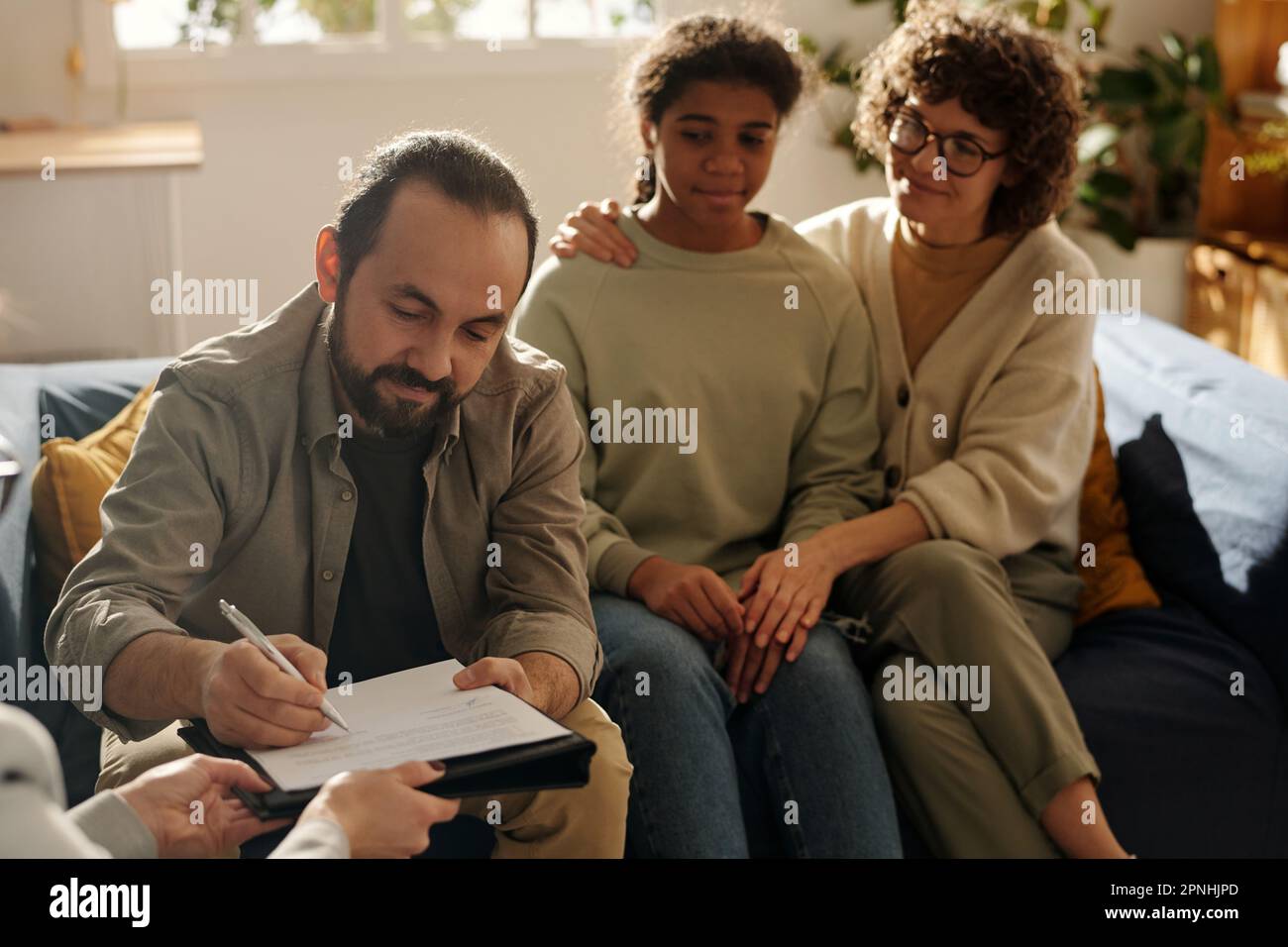 Dad signing custody contract during meeting with social worker with mom ...