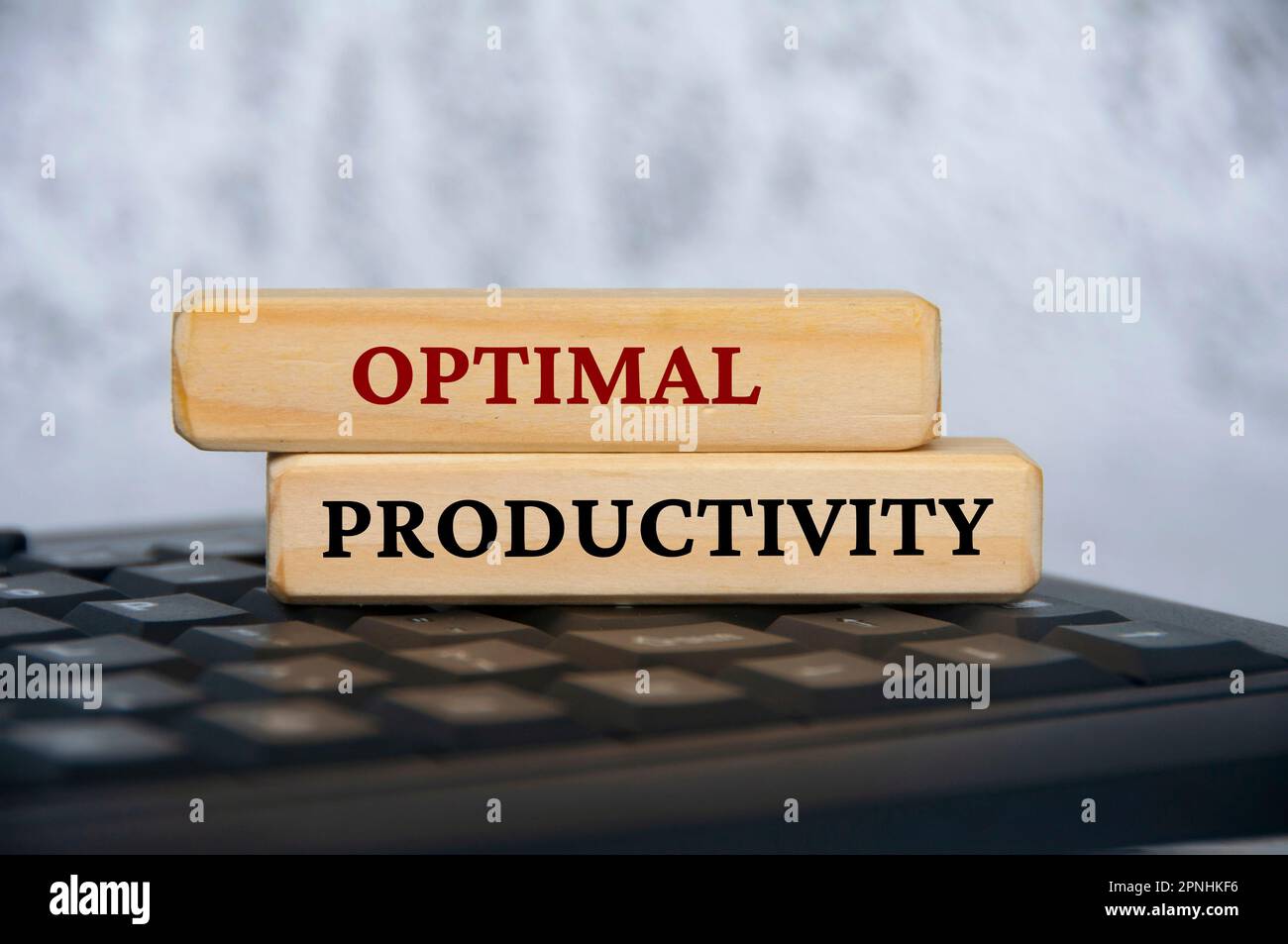 Optimal productivity text on wooden block with keyboard background ...