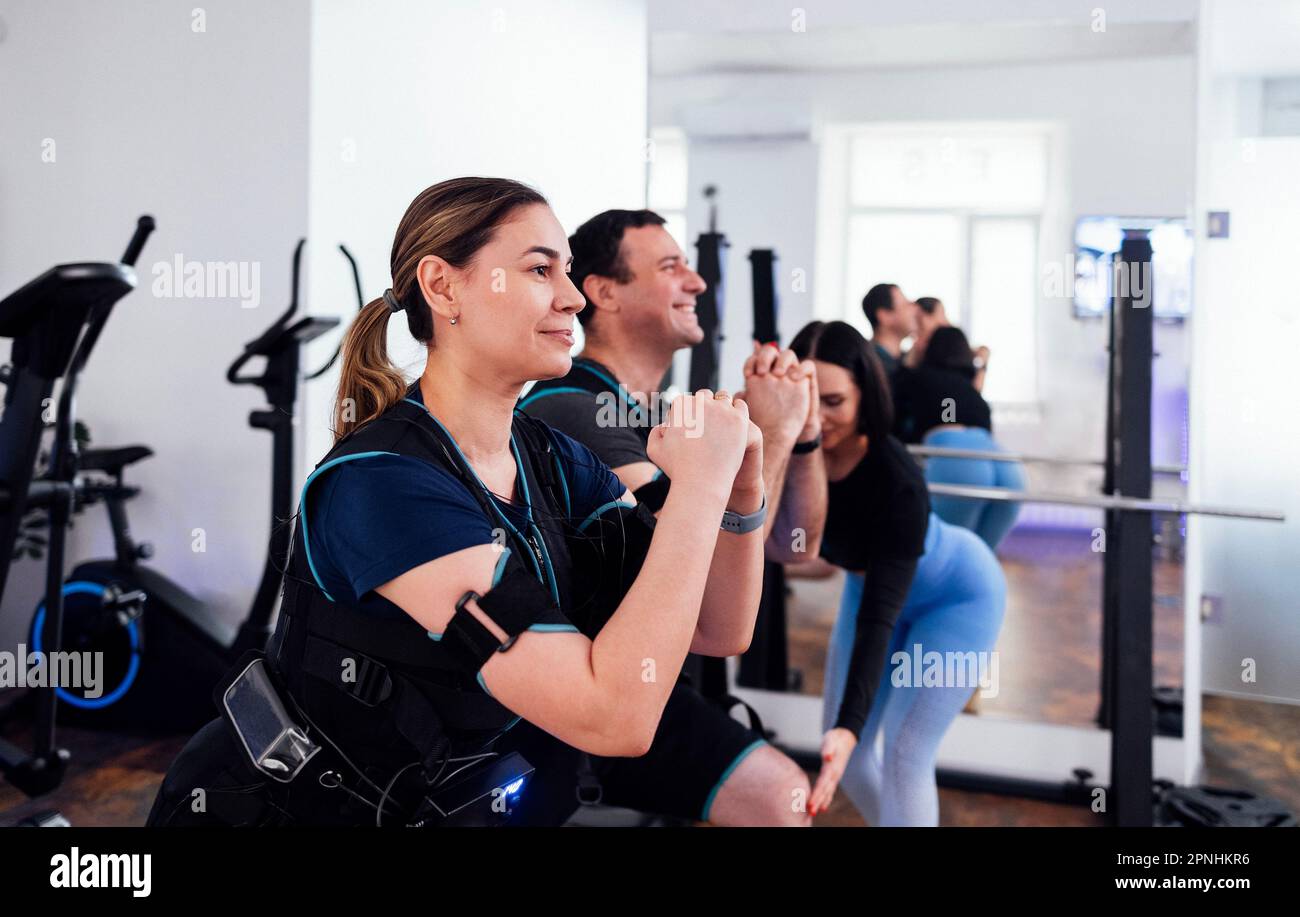 Young sports couple in ems suits is engaged in physical activity in gym ...
