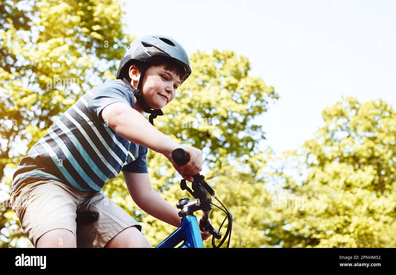Enjoying a bike ride around the block. a young boy riding his bicycle ...
