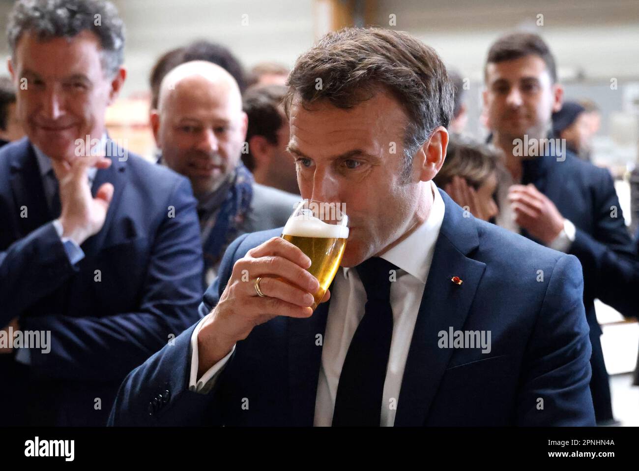 French President Emmanuel Macron drinks a beer during a visit to Mathis ...
