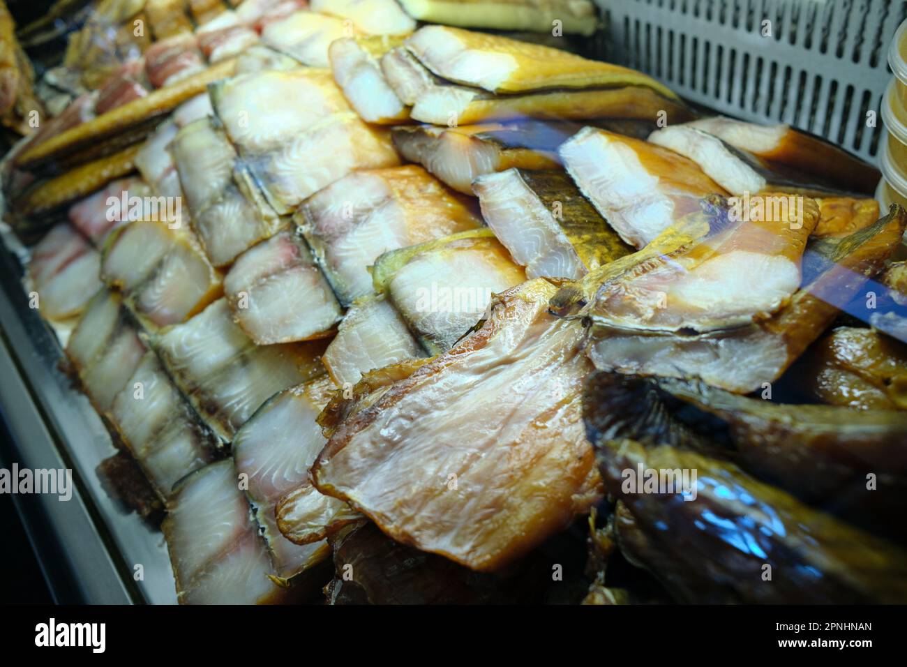 Balyk made of asp, carp and sturgeon lies on the counter. Shiny fat ...
