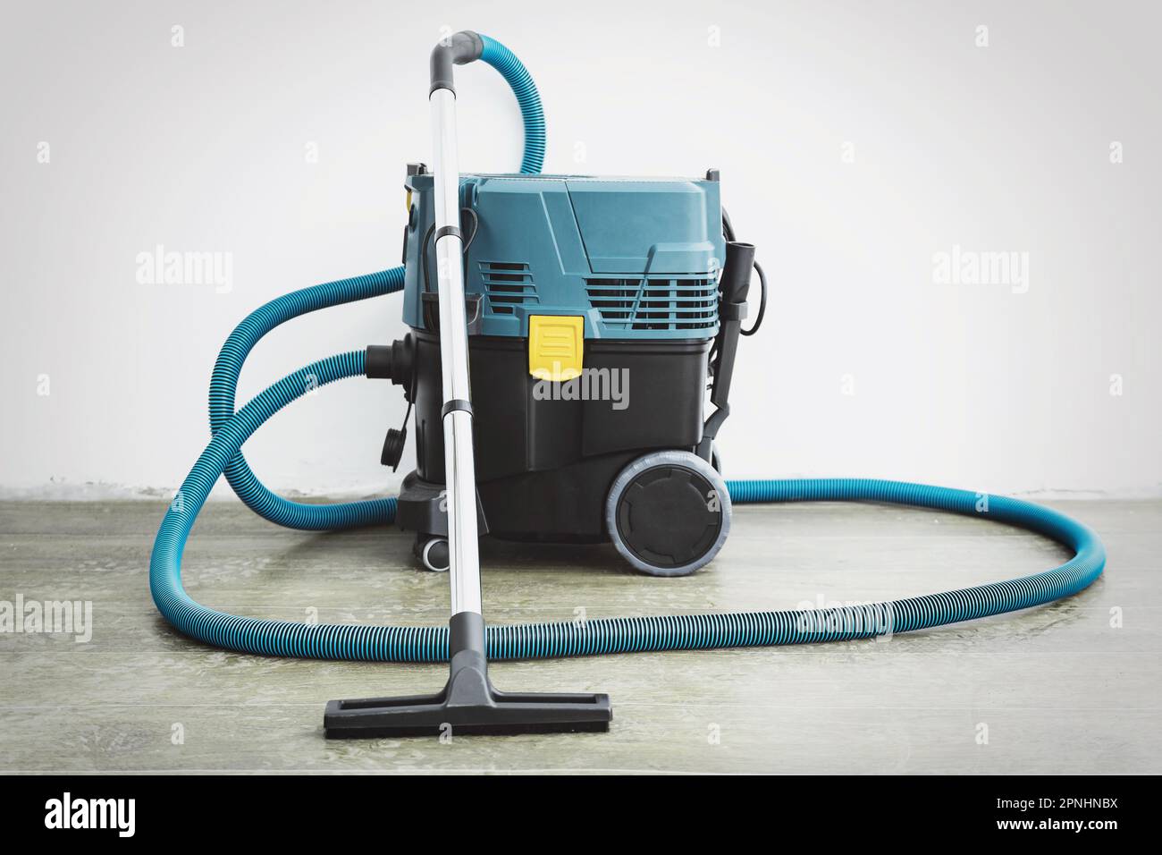 Powerful construction vacuum cleaner in an empty room after renovation ...