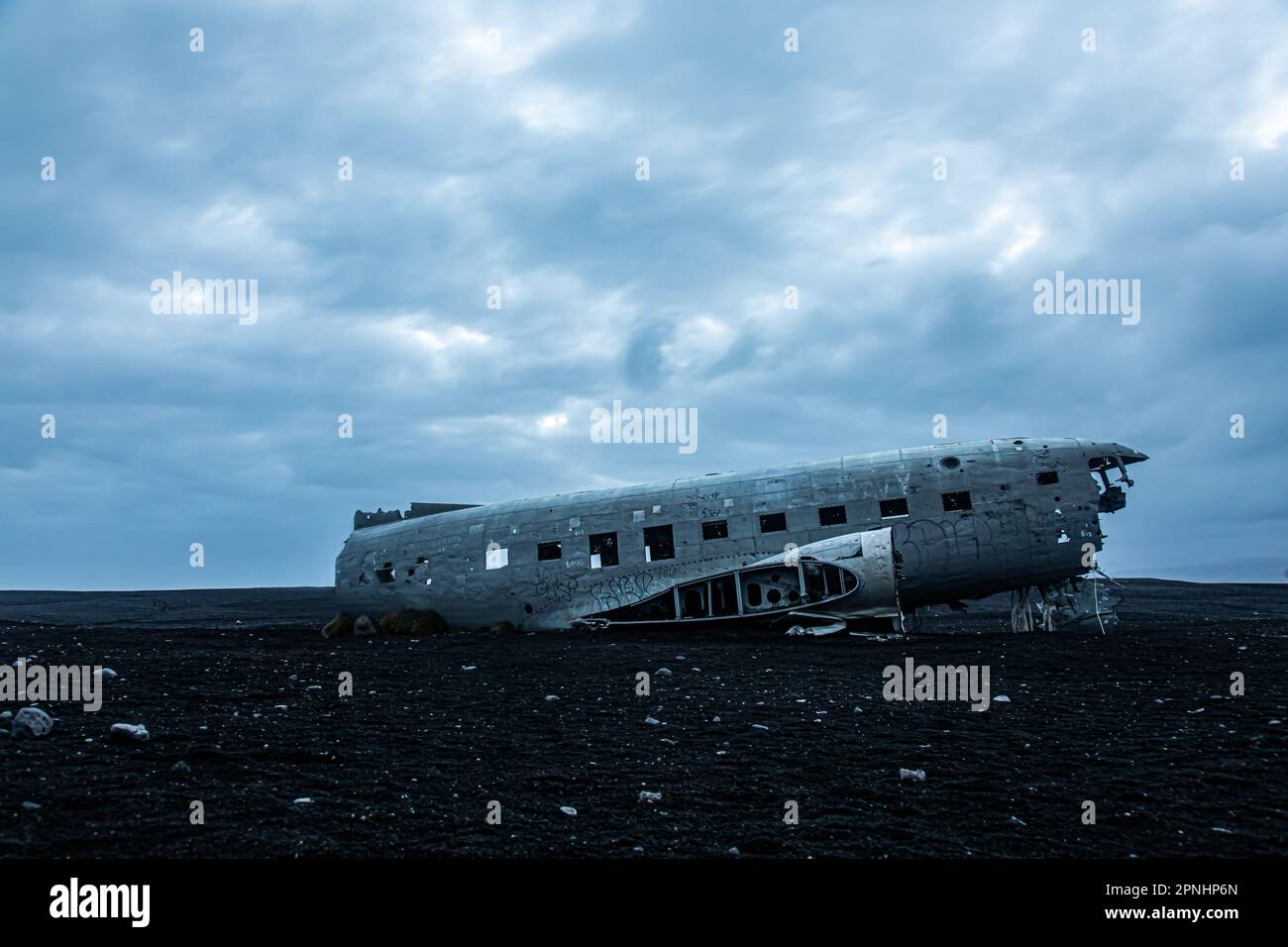 Sunset view of the old crashed plane wreck abandoned in a remoted black ...