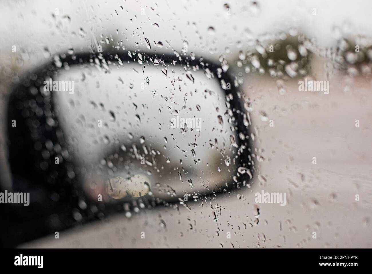 raindrops on the right mirror of the car, poor visibility. Bad weather ...