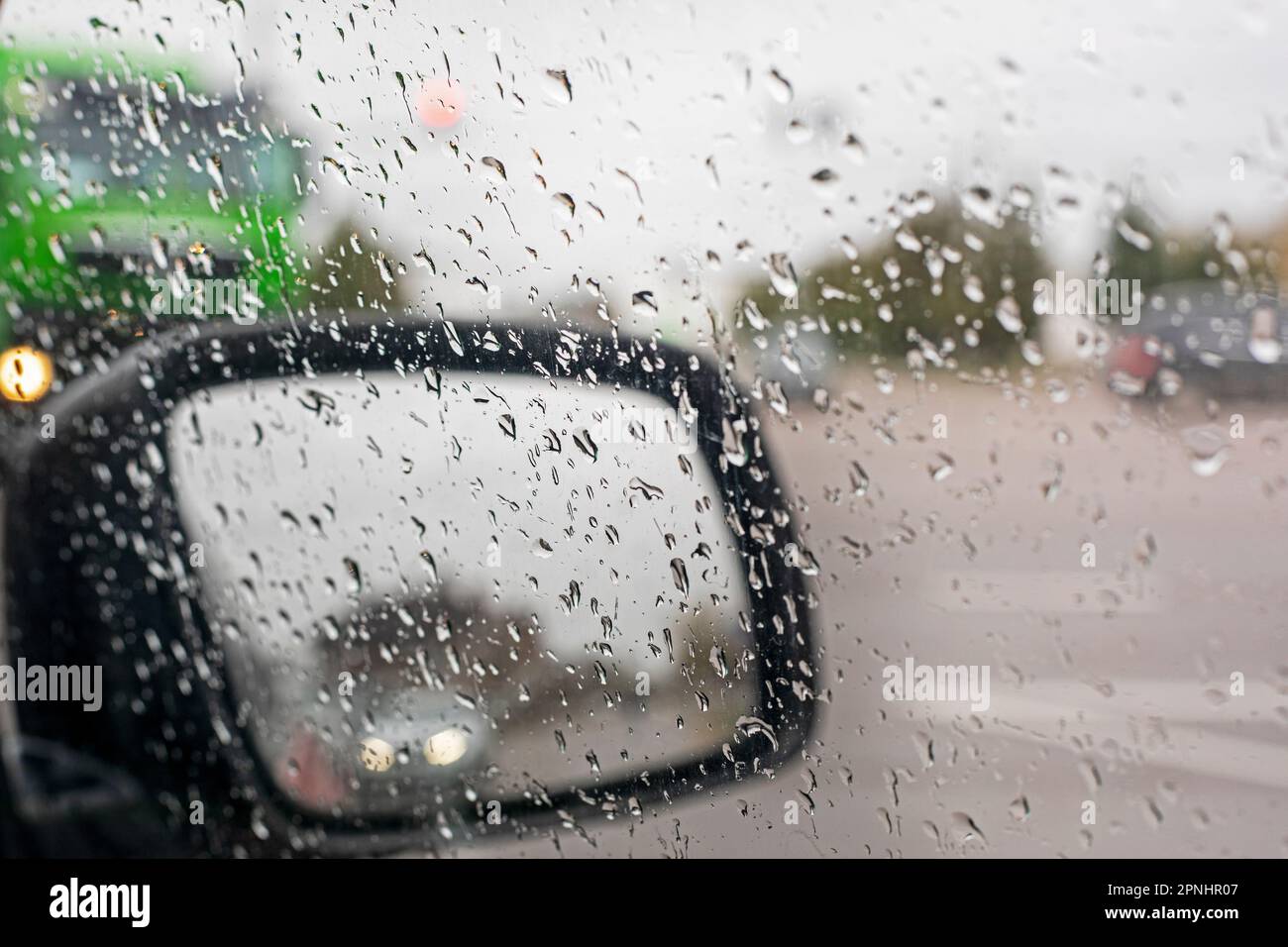 raindrops on the right mirror of the car, poor visibility on the road ...