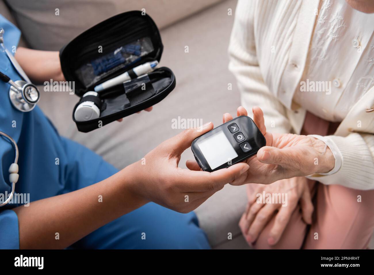 top view of multiracial nurse holding diabetes kit and giving ...