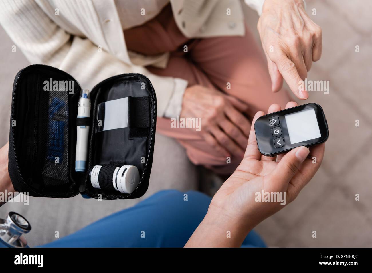 top view of cropped nurse holding diabetes kit and glucometer near ...