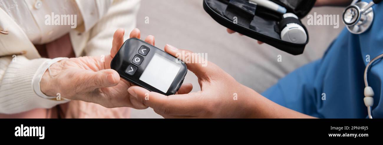 top view of multiracial nurse holding diabetes kit and giving ...