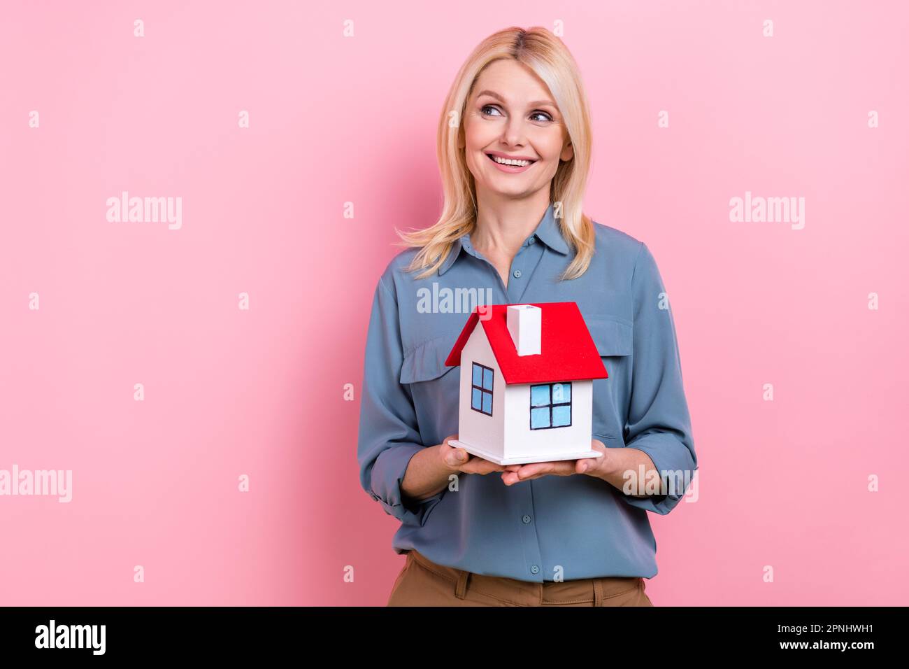 Photo of attractive senior business lady realtor hold cute little house ...