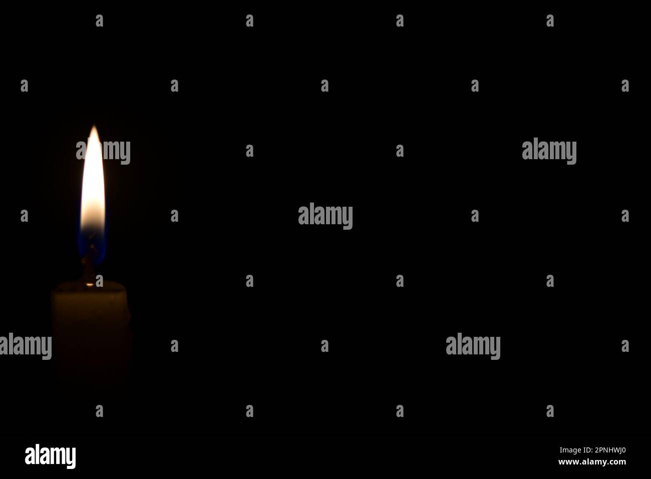 Burning candle on bottom left corner on a black background Stock Photo ...