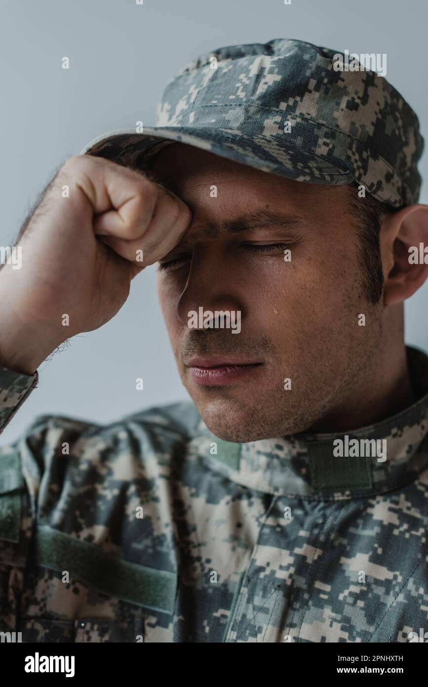 sad soldier in military uniform crying with closed eyes during memorial ...