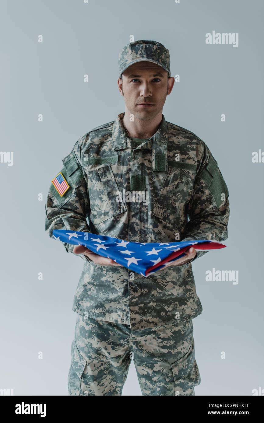 American soldier in uniform holding folded flag of United States during ...