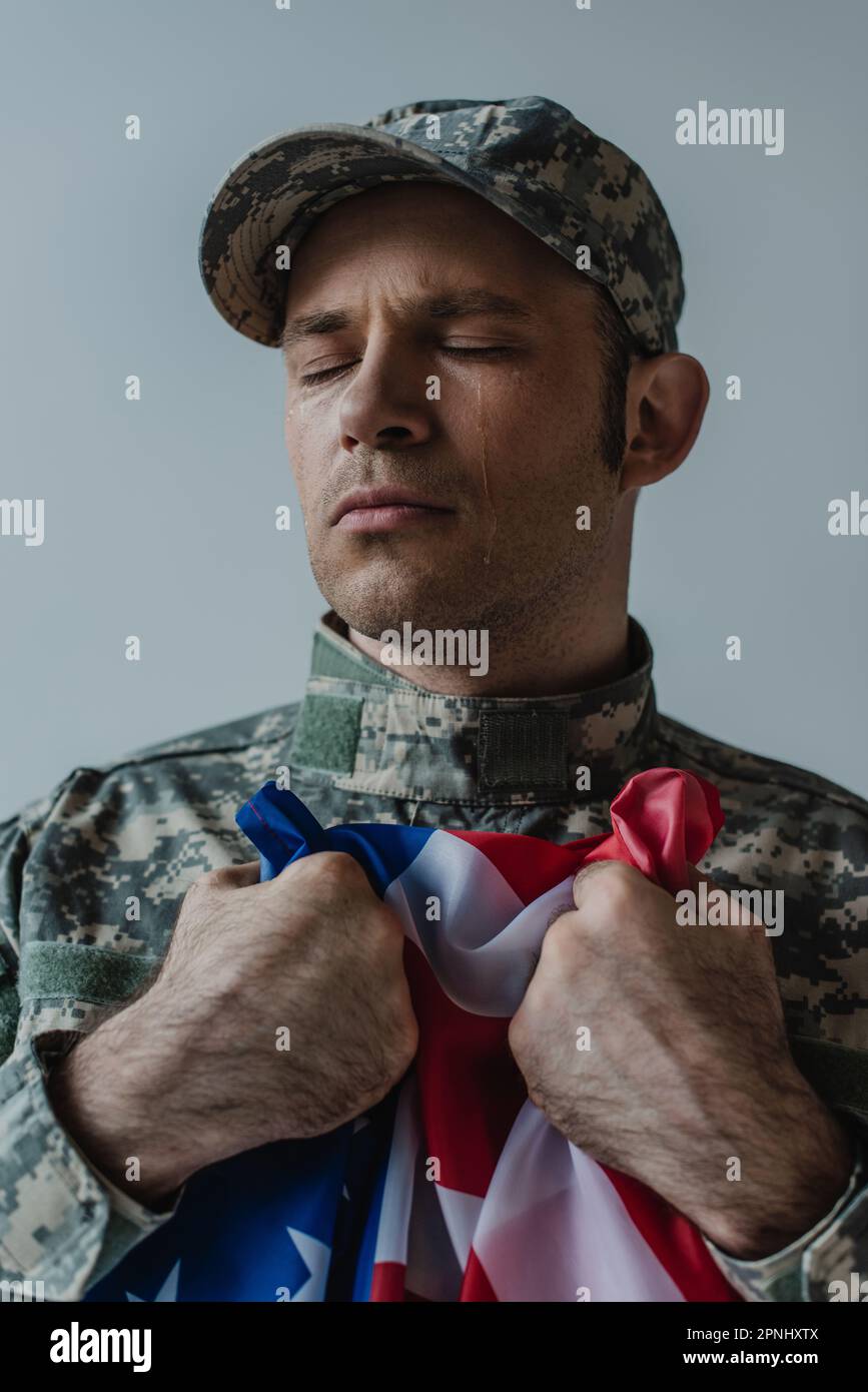 American soldier holding flag of United States while crying during ...