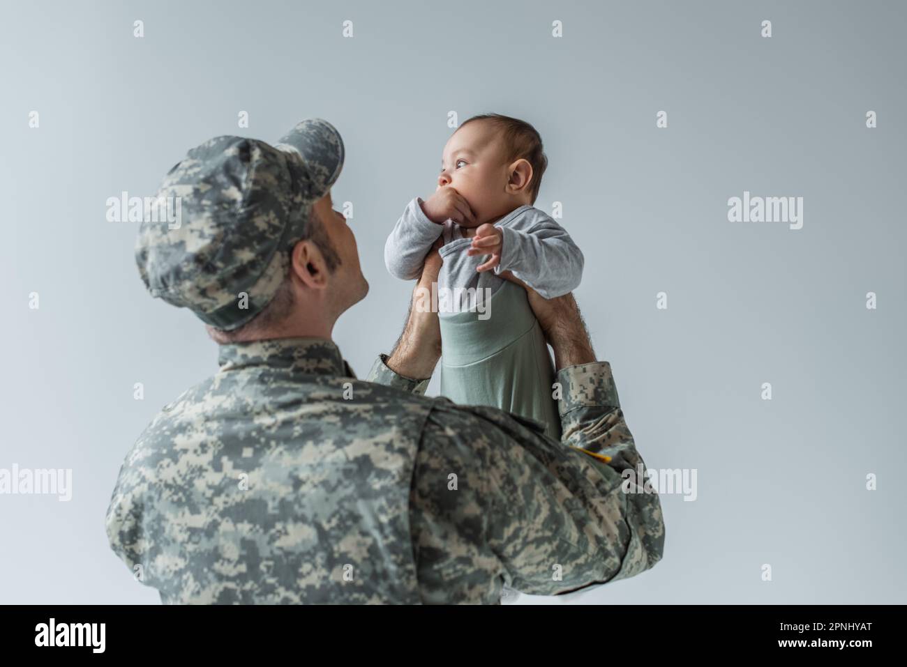 army soldier in uniform and cap holding baby boy in arms isolated on ...