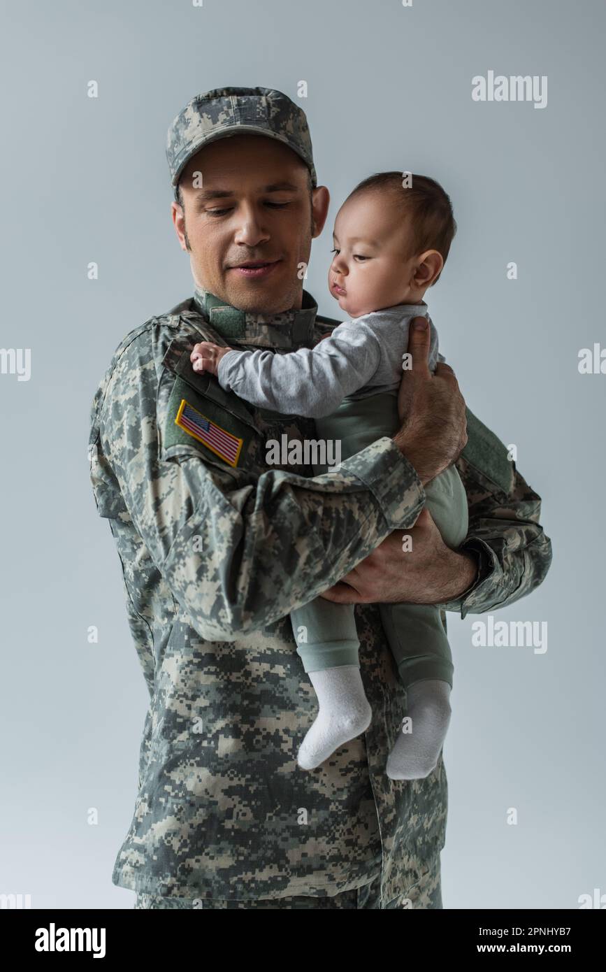 American army soldier in military uniform with cap holding infant son ...