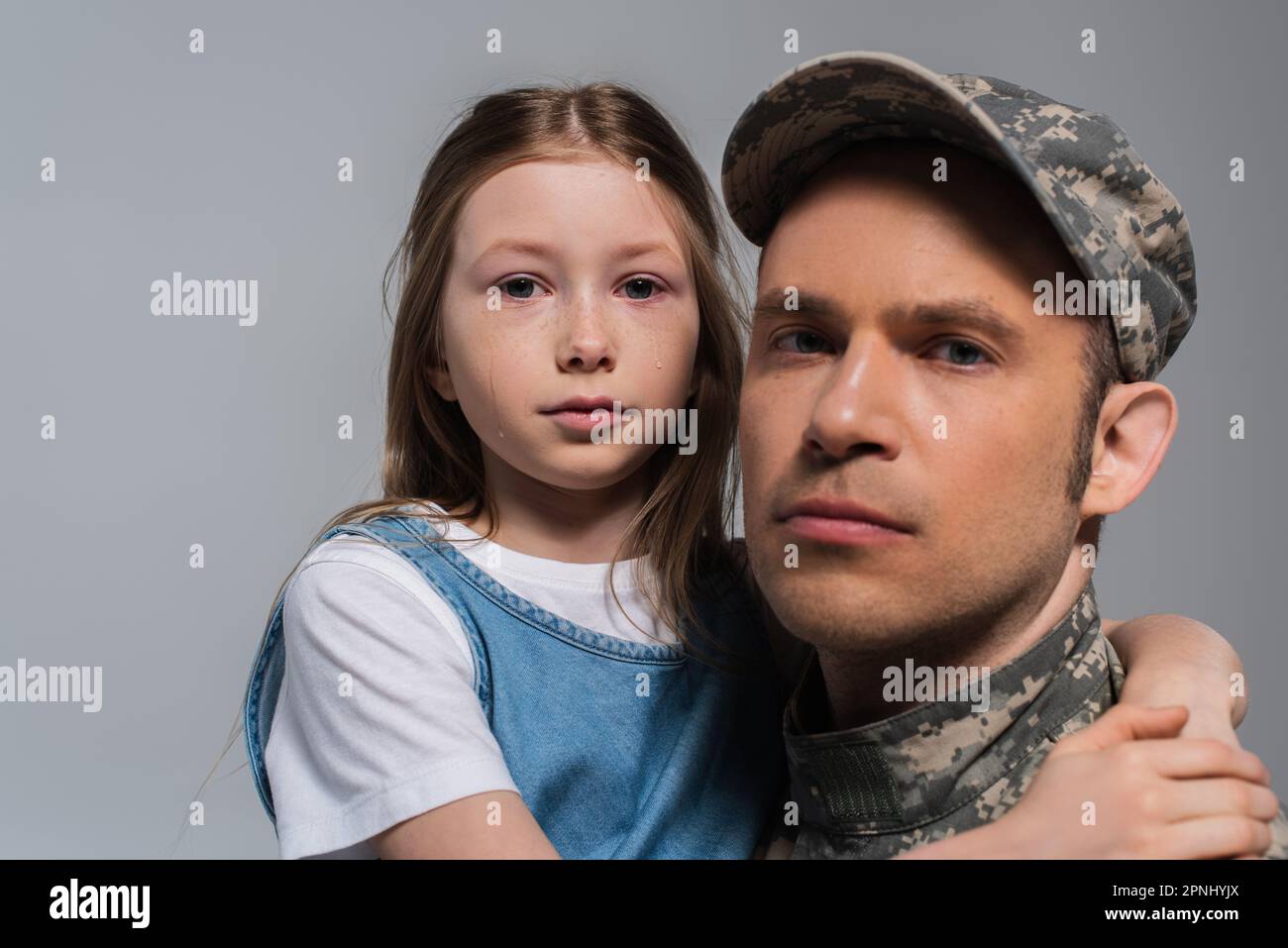 patriotic kid hugging father in military uniform and crying during ...