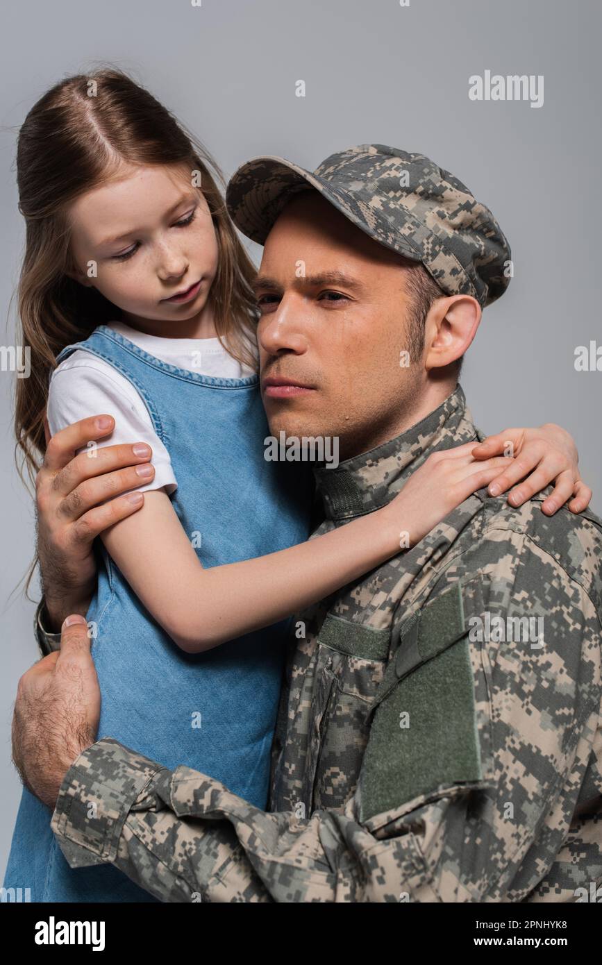 sad girl hugging serviceman in military uniform crying during memorial ...