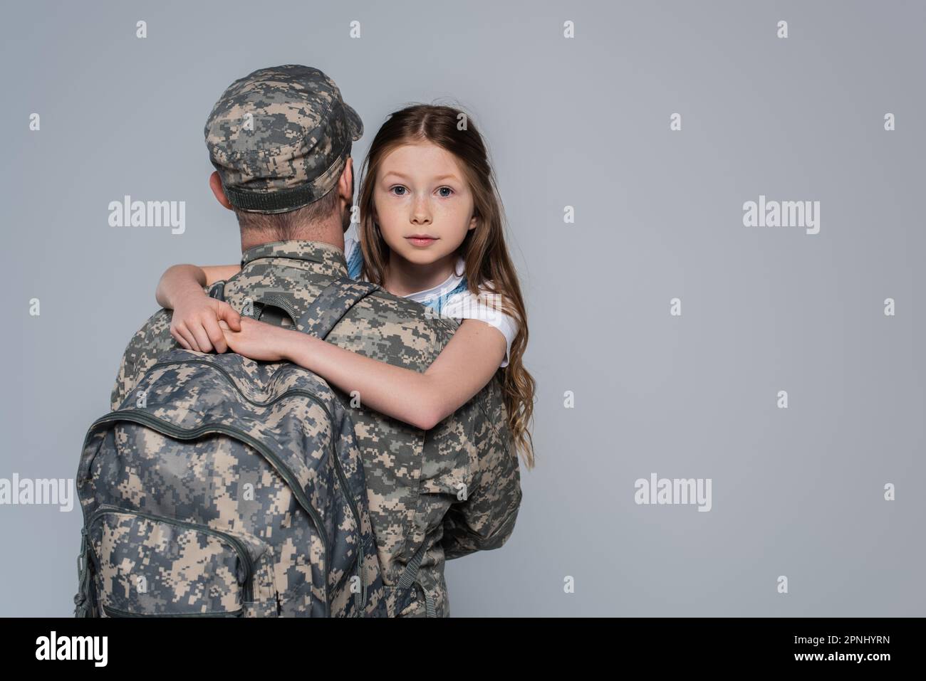 daughter hugging father in military uniform during homecoming isolated ...