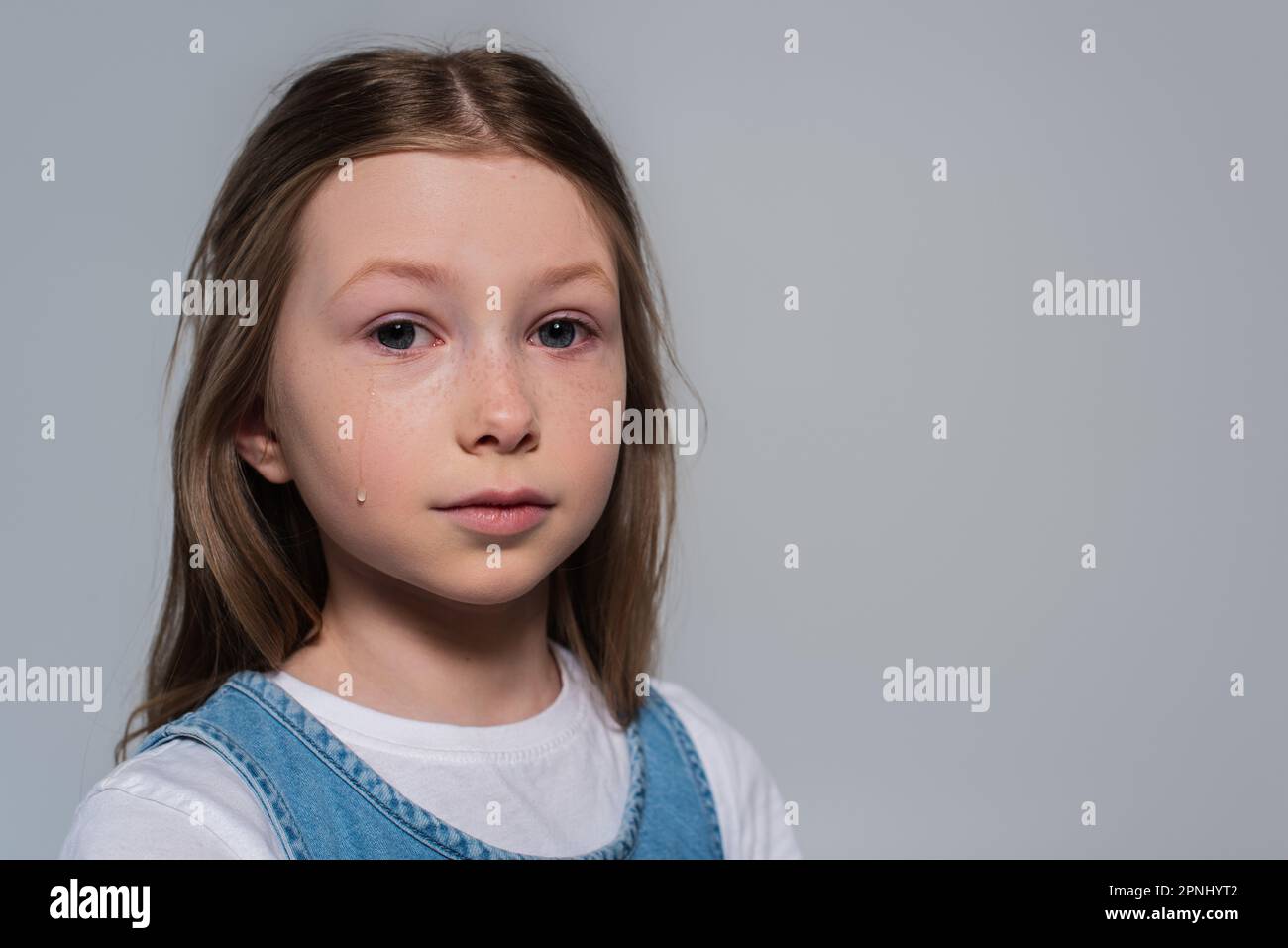 patriotic girl looking at camera and crying during memorial day ...