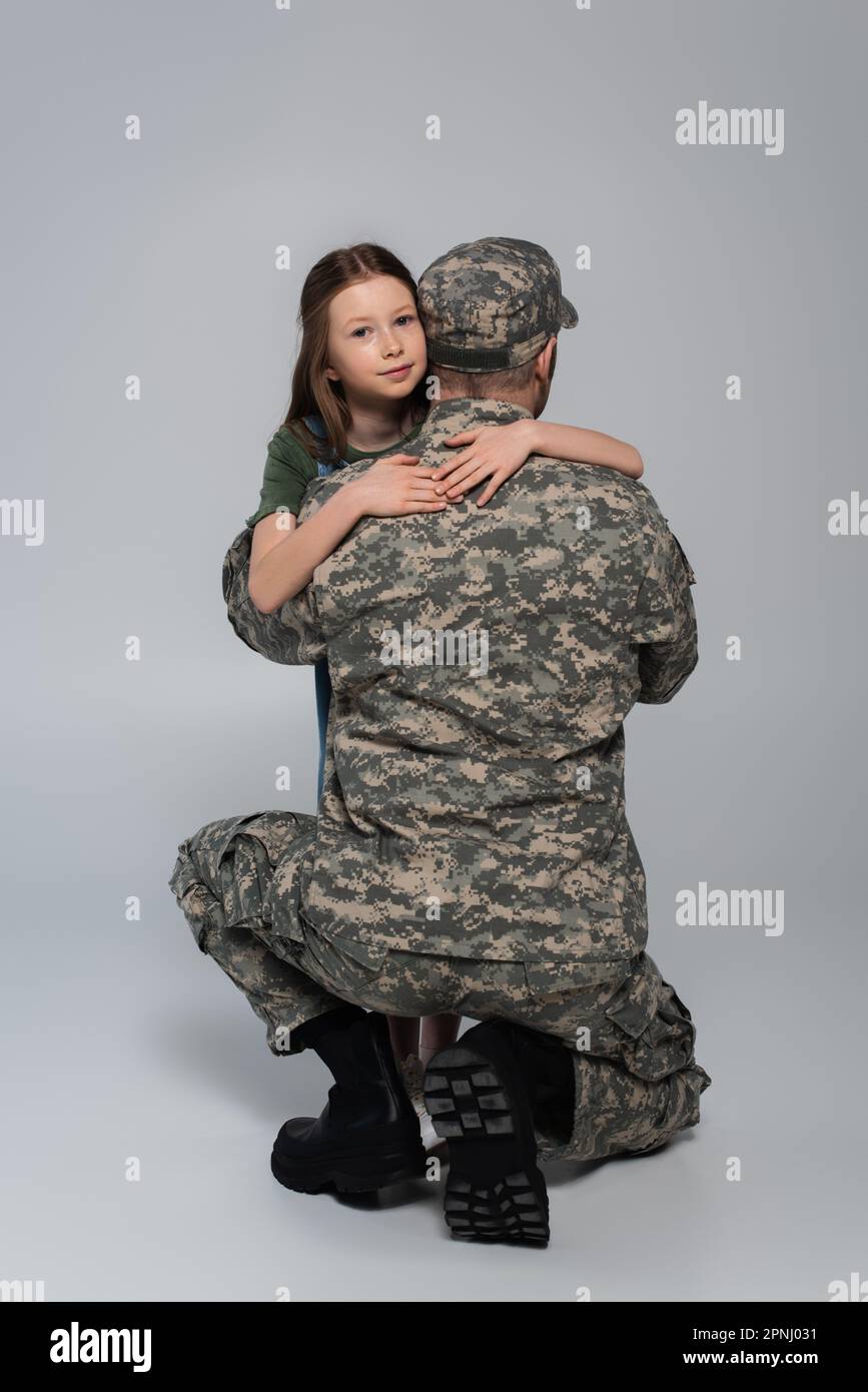 preteen kid hugging serviceman in military uniform during memorial day ...